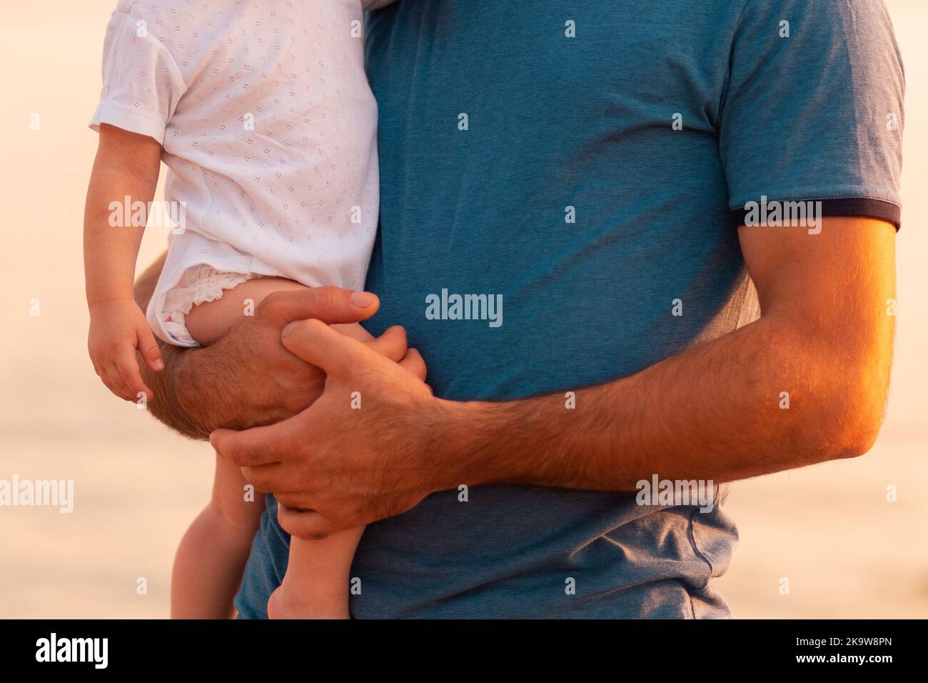 Fatherhood. Man is holding child in his arms, close-up. Father embraces ...
