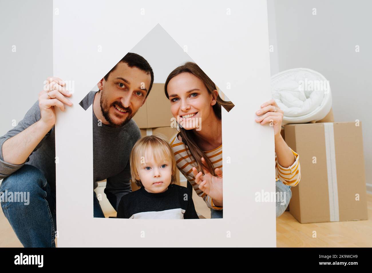 A family portrait taken through a cardboard frame in the shape of a ...