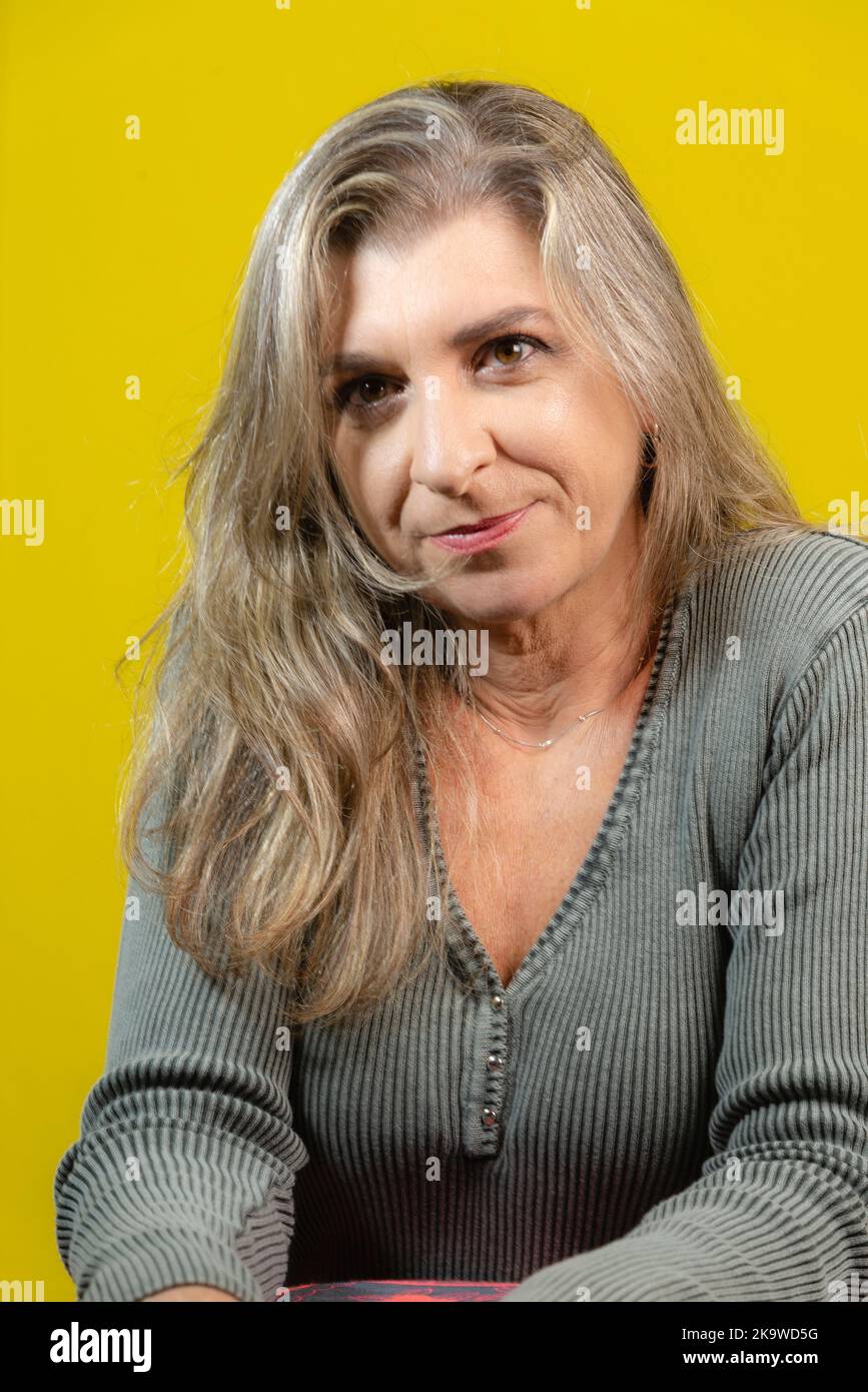 Beautiful model against yellow background. She wears gray colored ...