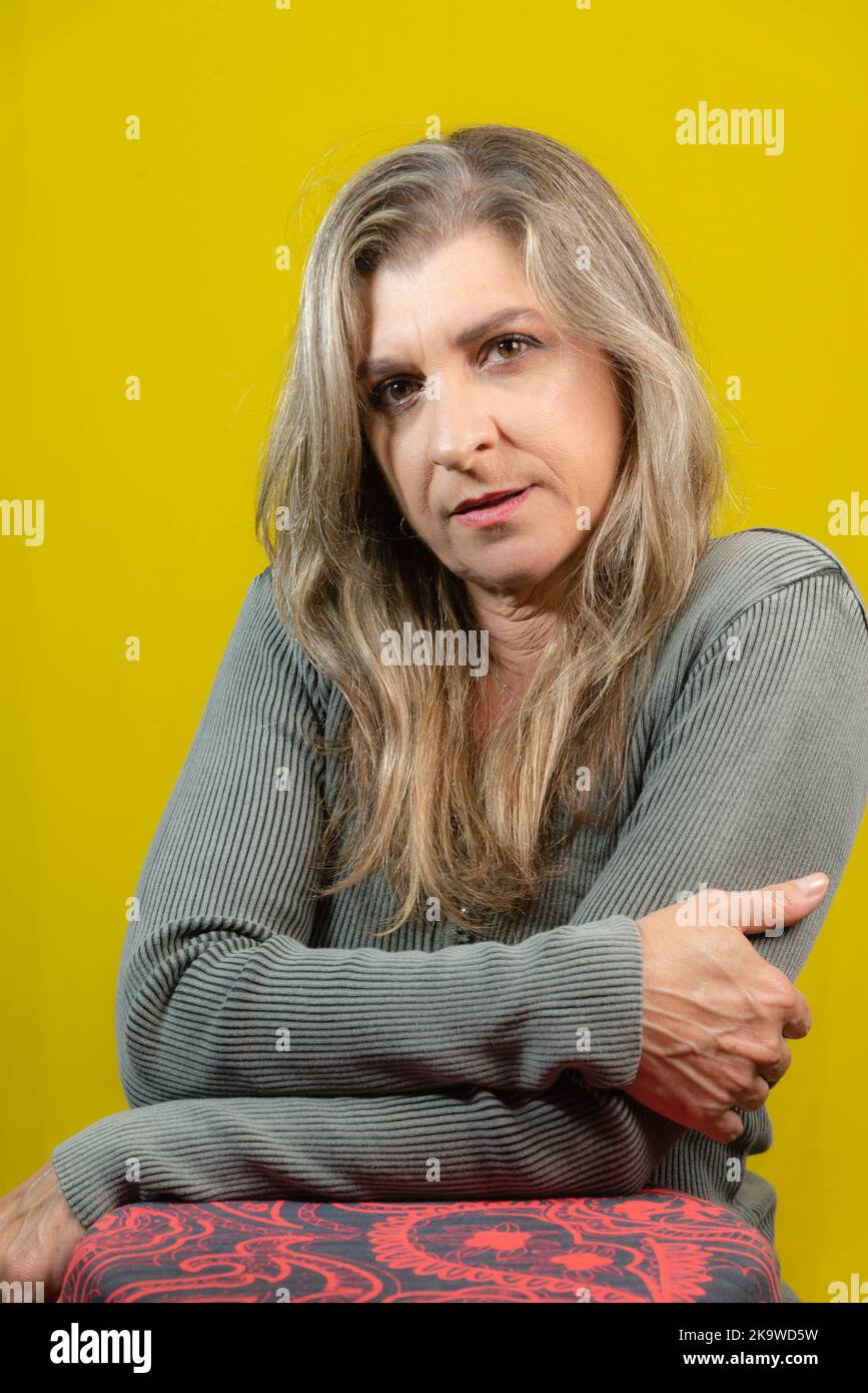 Beautiful model against yellow background. She wears gray colored ...