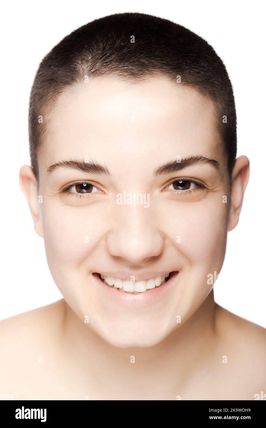 studio portrait of a beautiful young woman with very short hair against ...