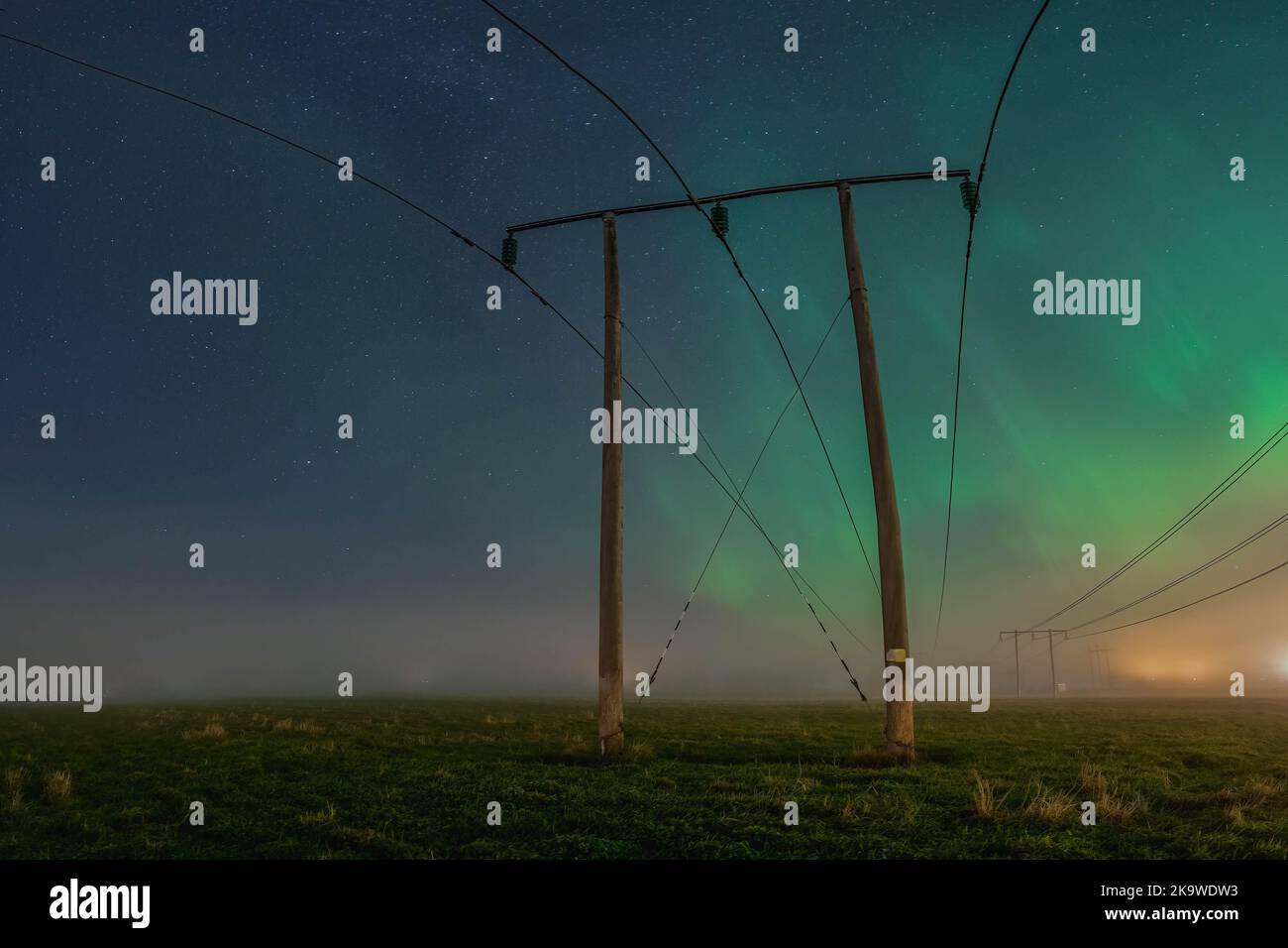 Beautiful night Aurora over double wooden pole power lines in autumn ...