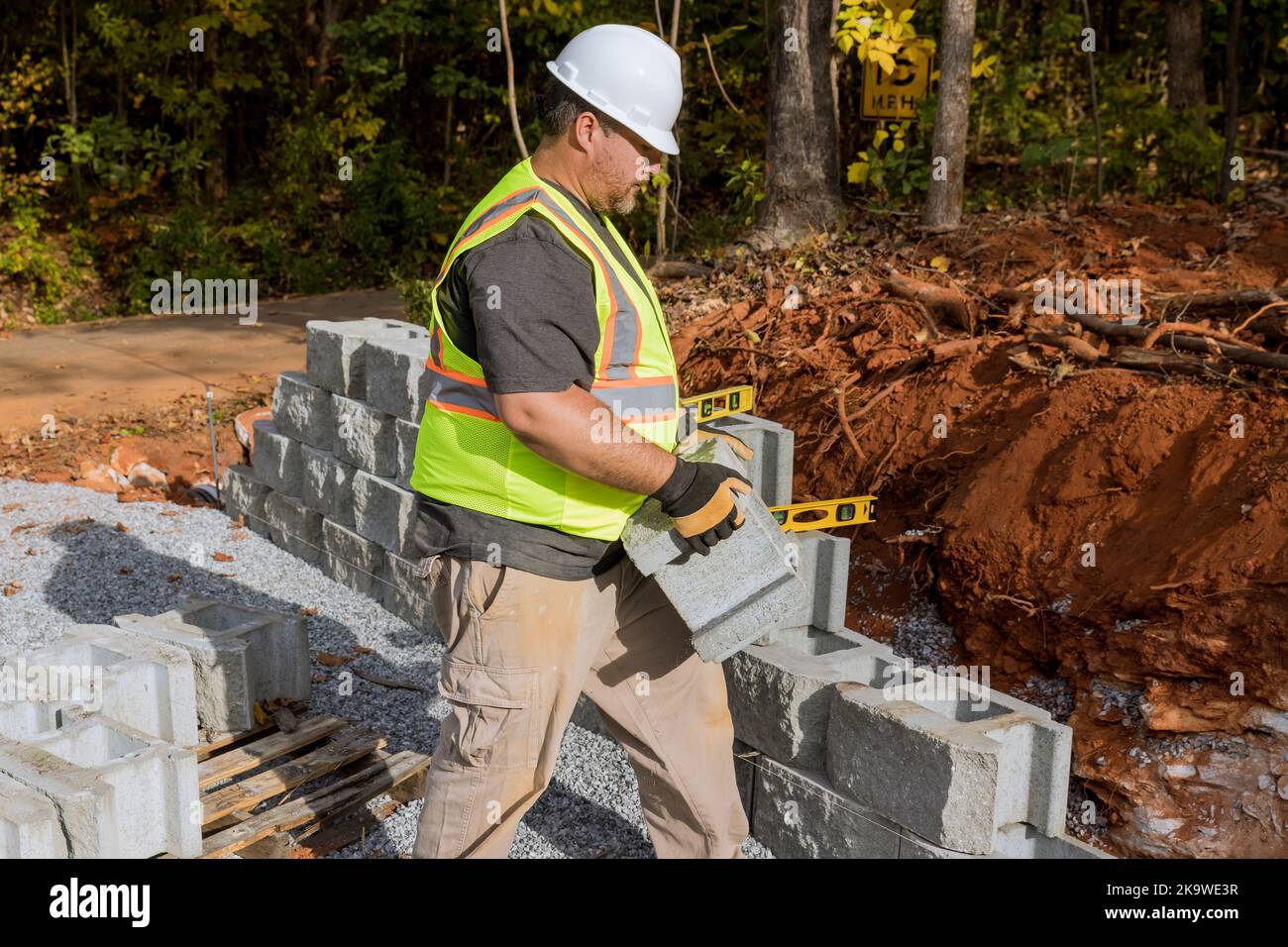 Contractor is constructing a block retaining wall on a construction ...