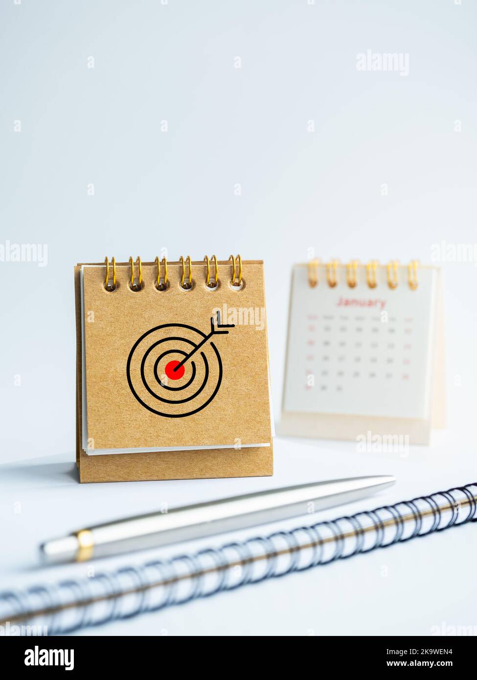 Target icon on 2023 year desk calendar cover near spiral notepad and ...