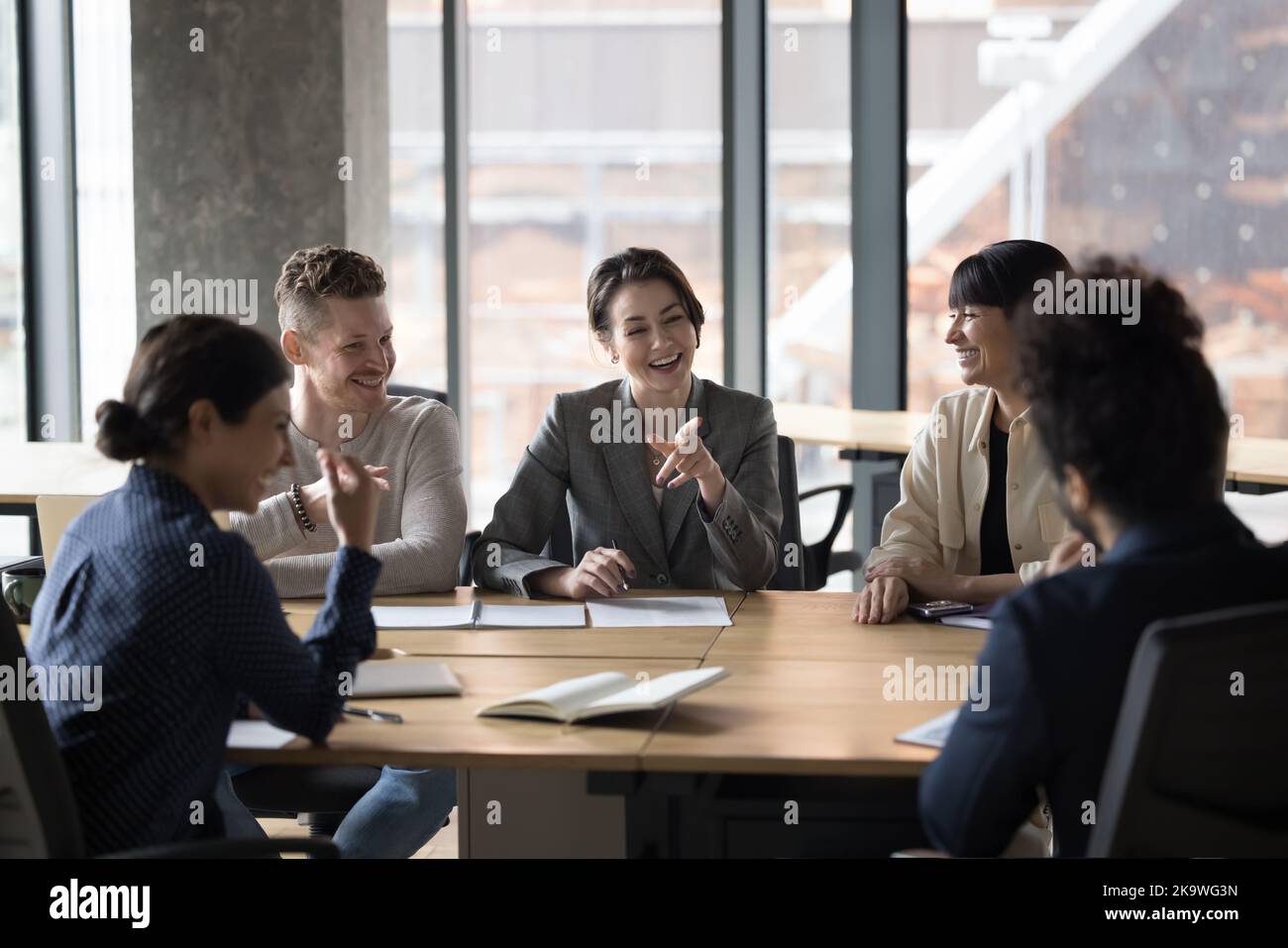 Happy diverse businesspeople laugh, brainstorm, discuss business ideas ...