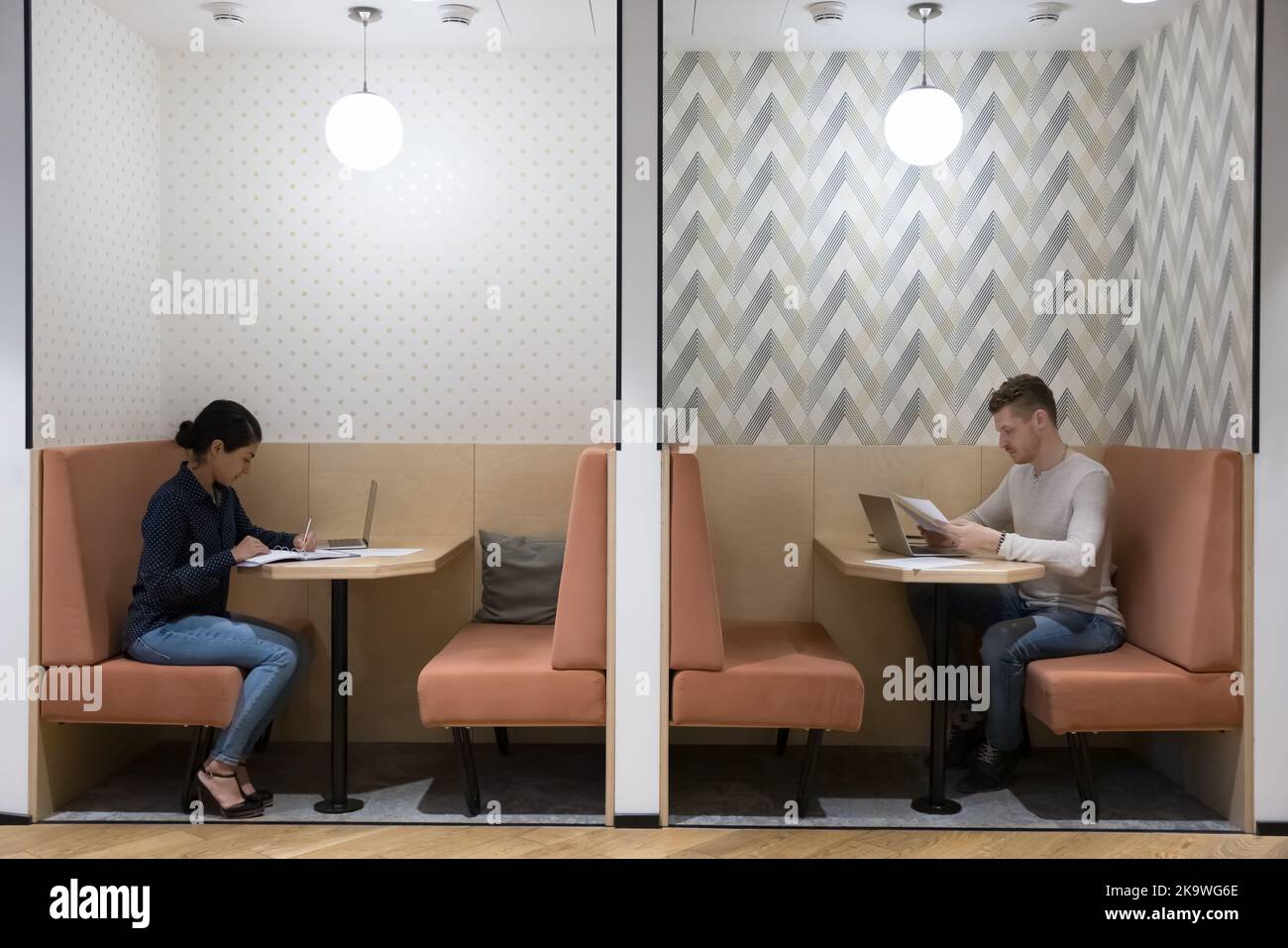Two young freelancers working seated at tables in modern coworking Stock Photo - Alamy