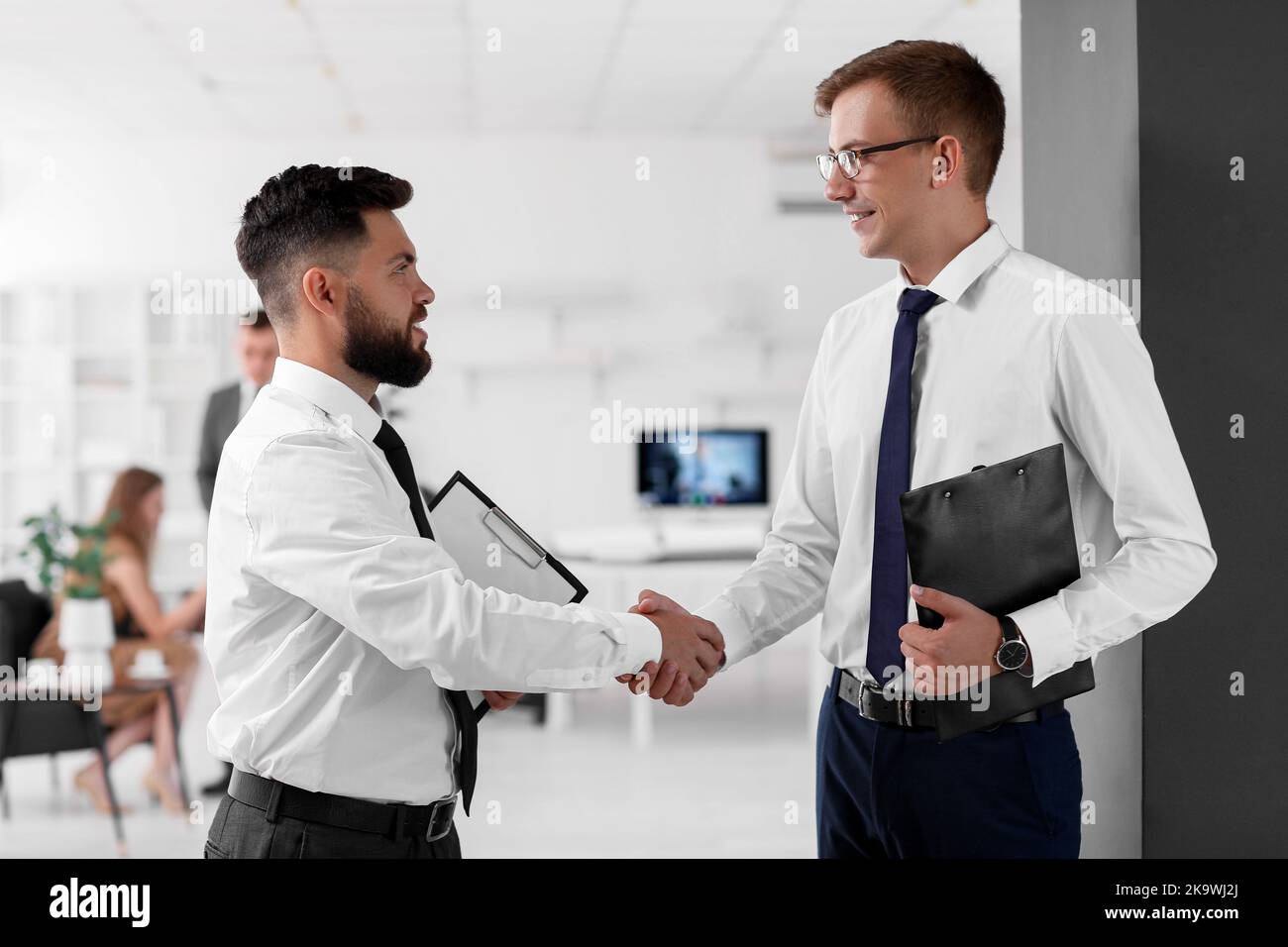 Male bank manager and his colleague shaking hands in office Stock Photo ...