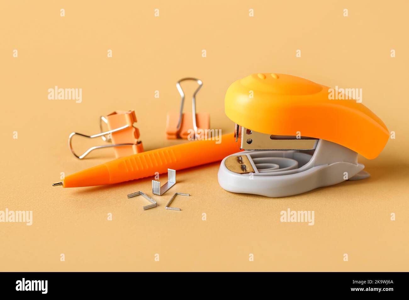 Office stapler, pen and paper clips on color background Stock Photo - Alamy