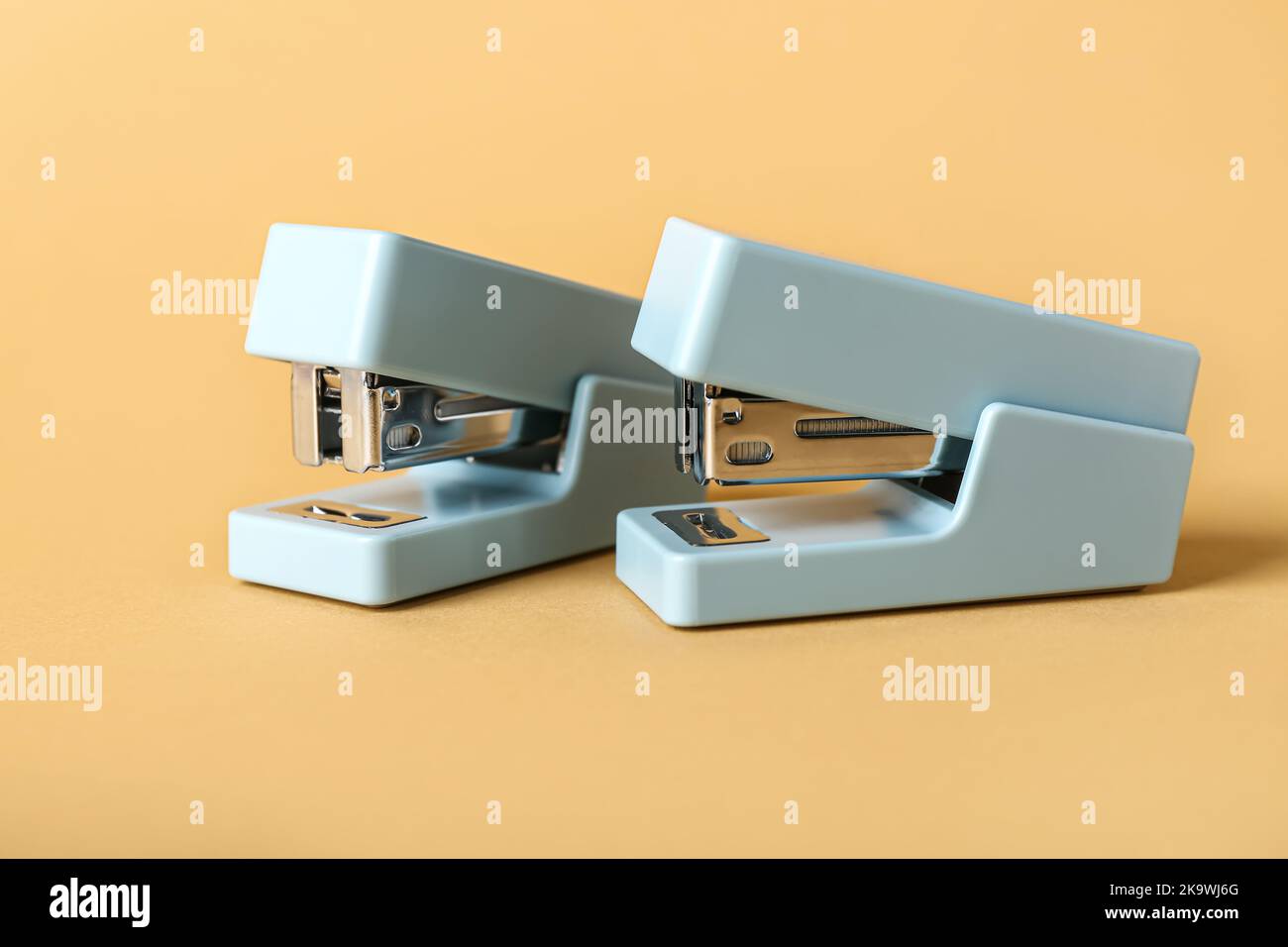 Office staplers on color background Stock Photo - Alamy
