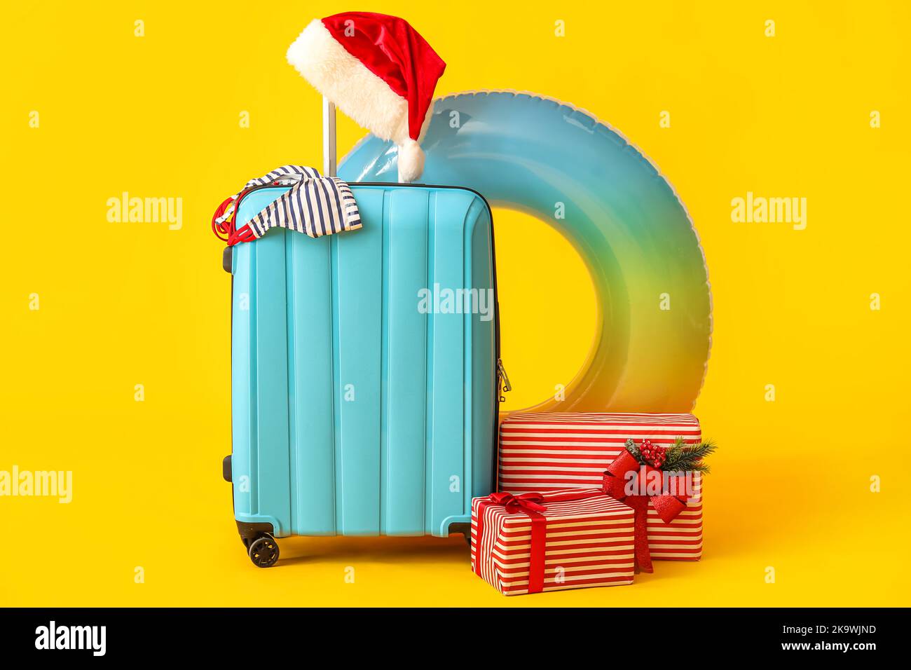 Suitcase with Santa hat, Christmas gifts and travel accessories on ...