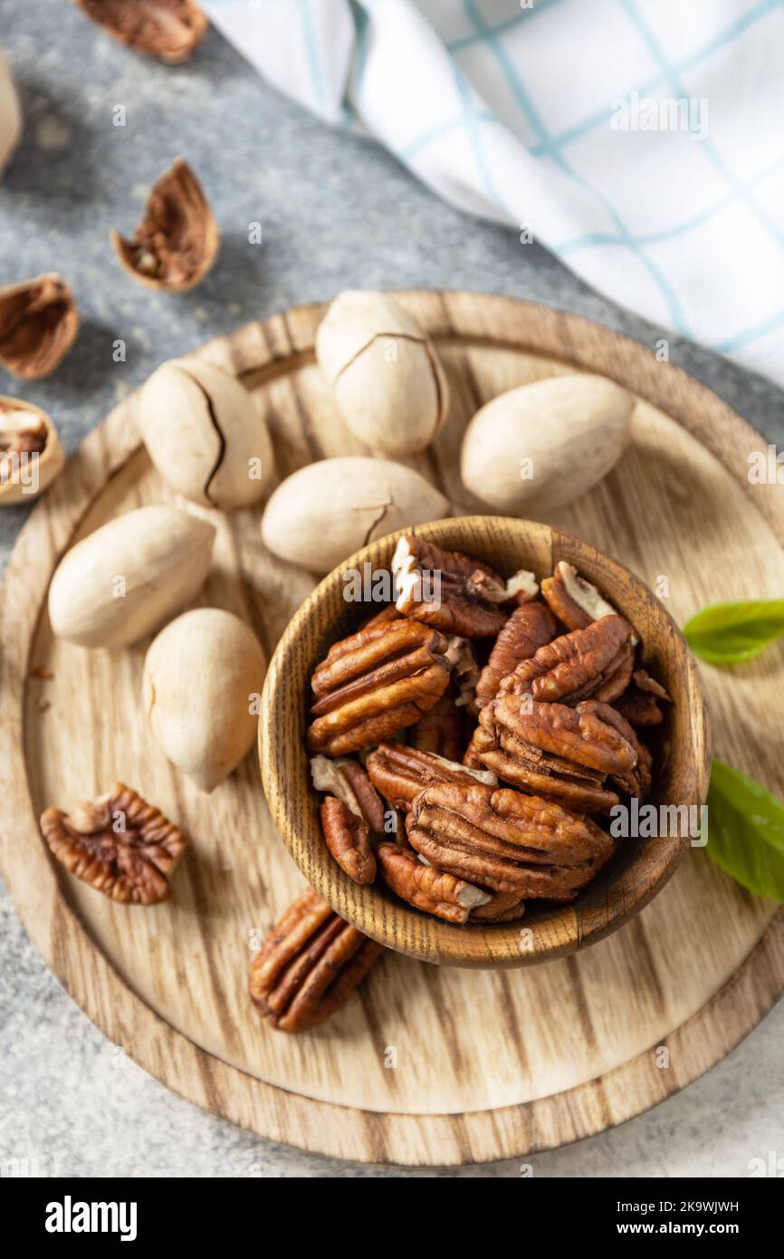 Bowl with pecan nuts on a stone table. Nuts and seeds, healthy fats ...