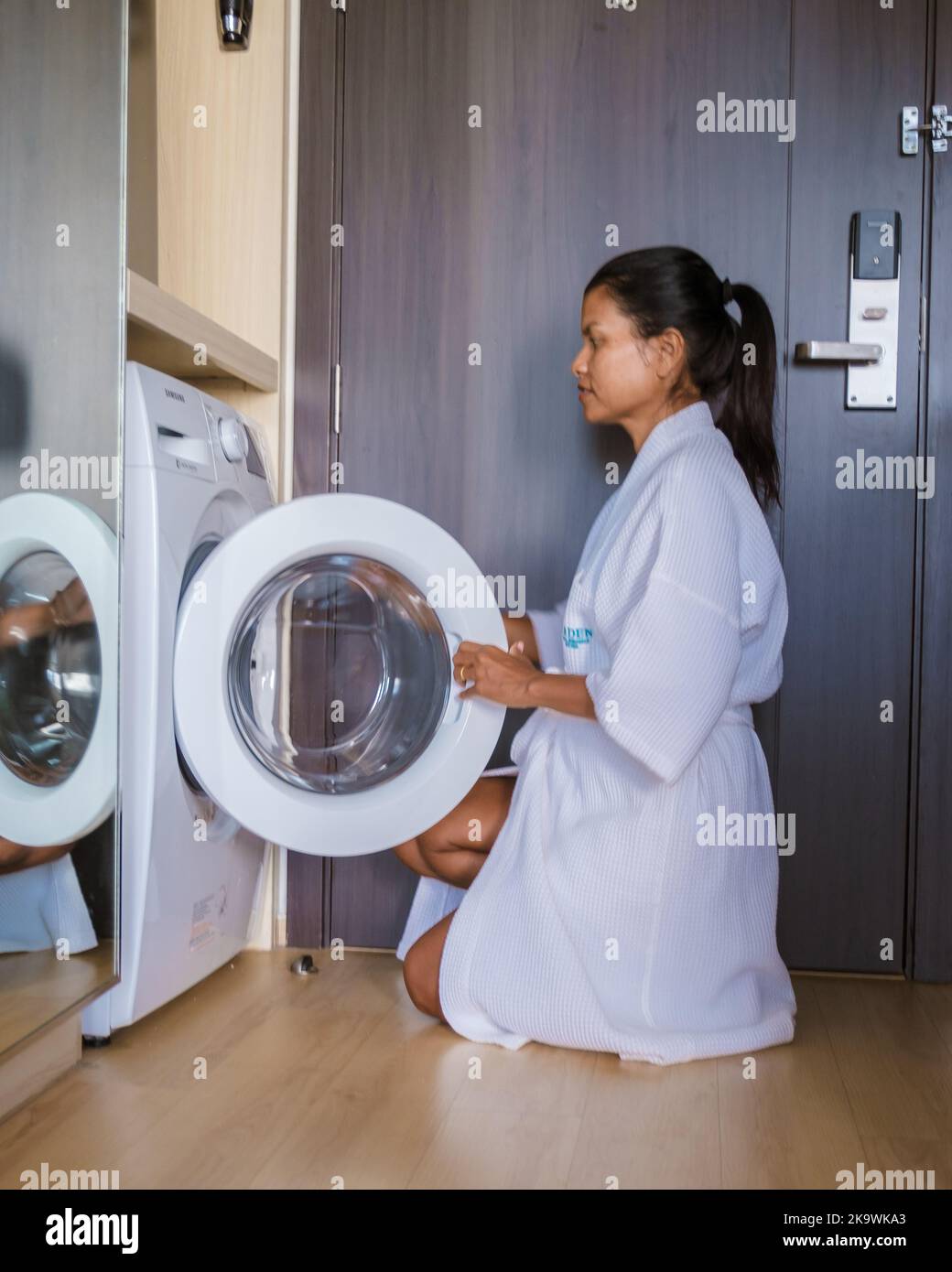 Women do the laundry by putting clothes in a machine. women with a ...