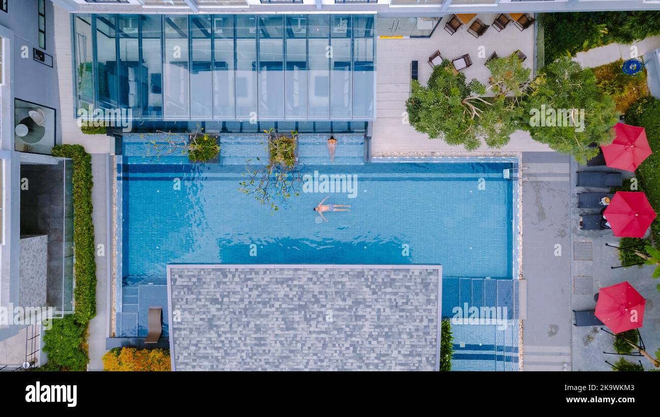 Drone view from above at the swimming pool. Couple men and women in ...