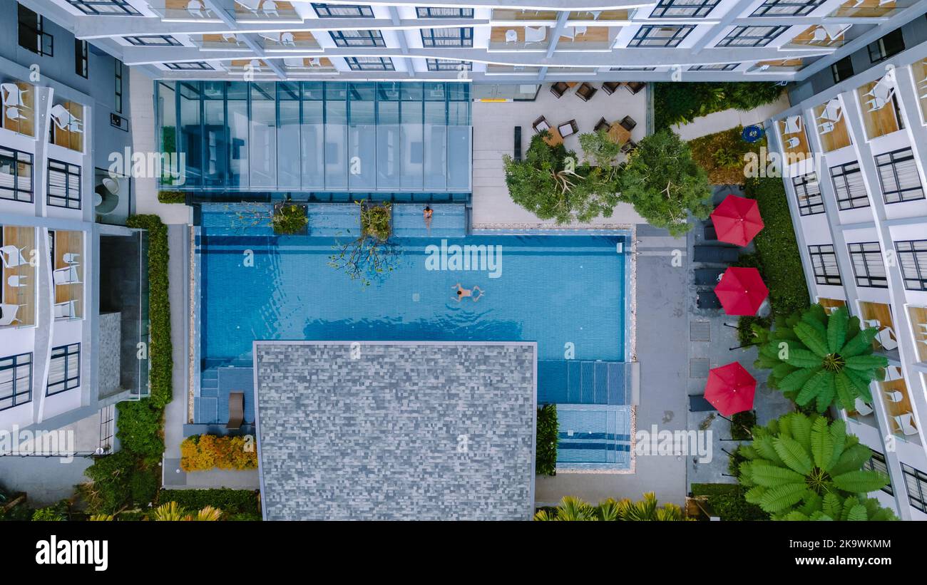 Drone view from above at the swimming pool. Couple men and women in ...