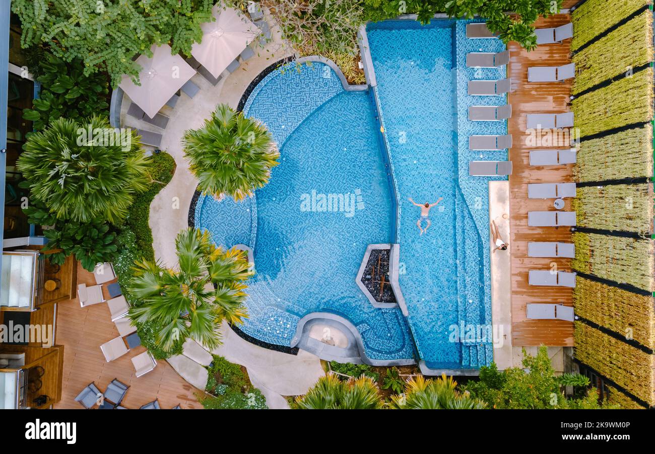 Drone view from above at the swimming pool. Couple men and women in ...