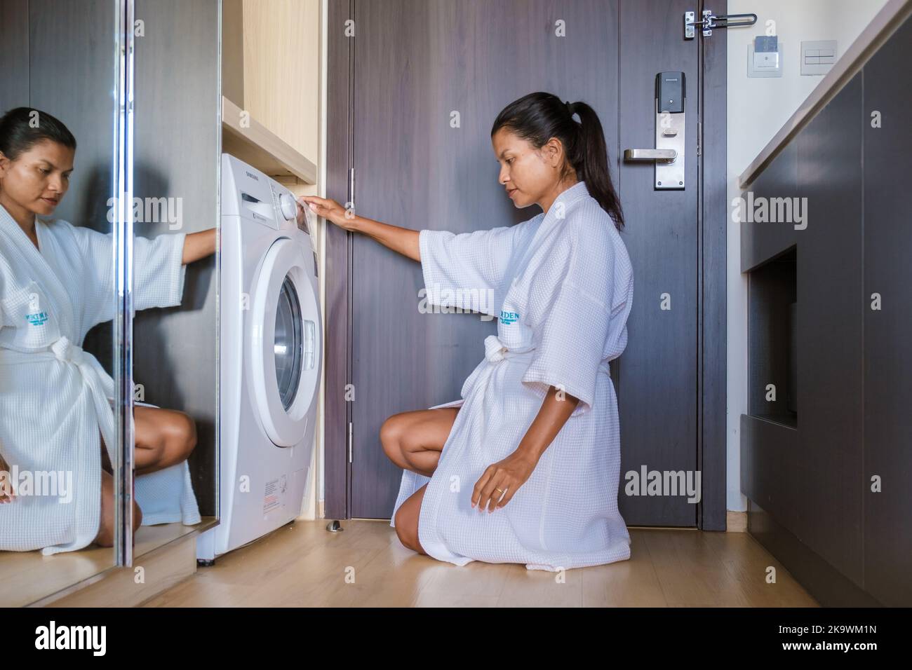 Women do the laundry by putting clothes in a machine. women with a ...
