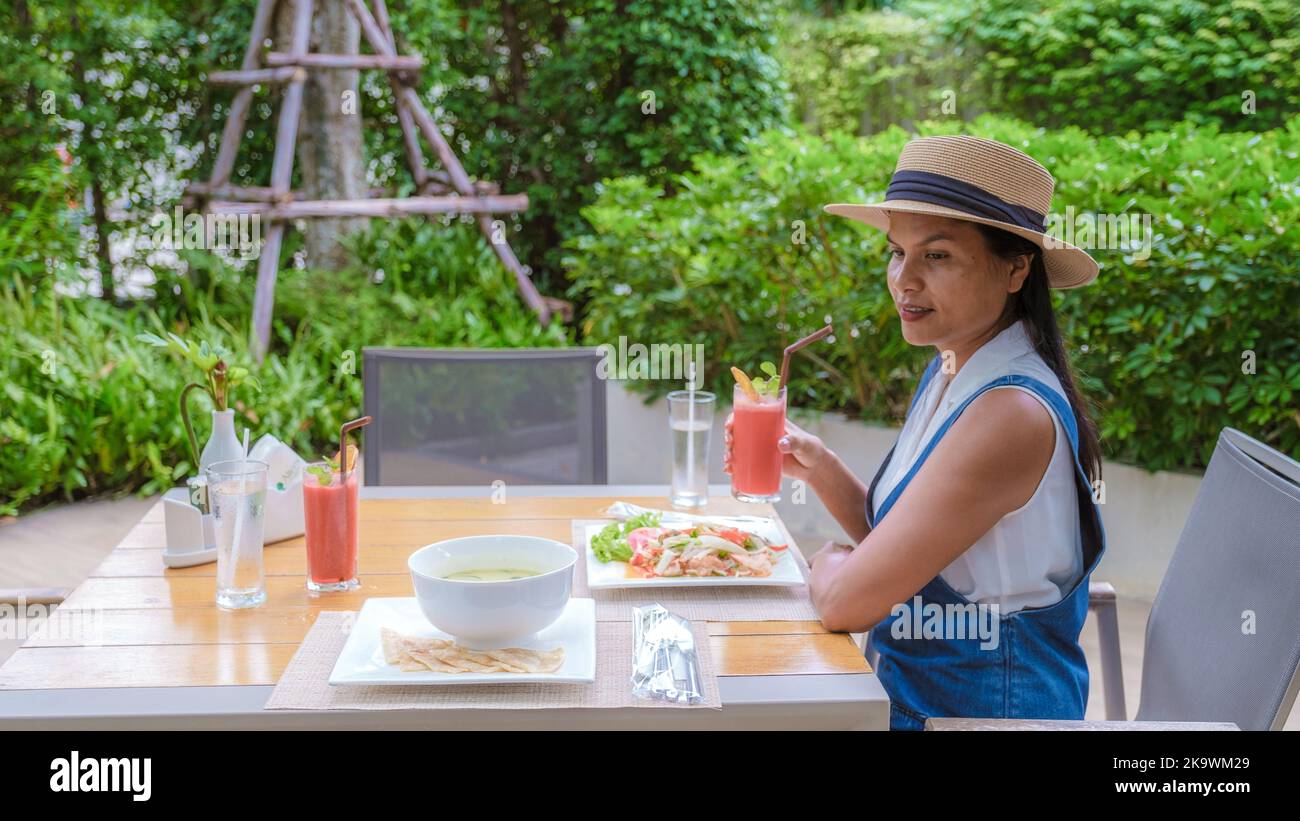 Dinner table in the evening in a hotel in Thailand. Thai women having ...