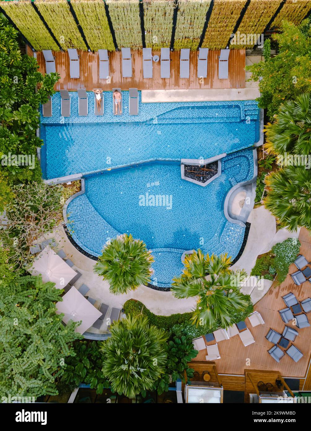 Drone view from above at the swimming pool. Couple men and women in ...