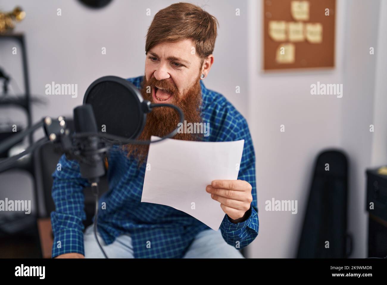 Young redhead man musician smiling confident singing song at music ...