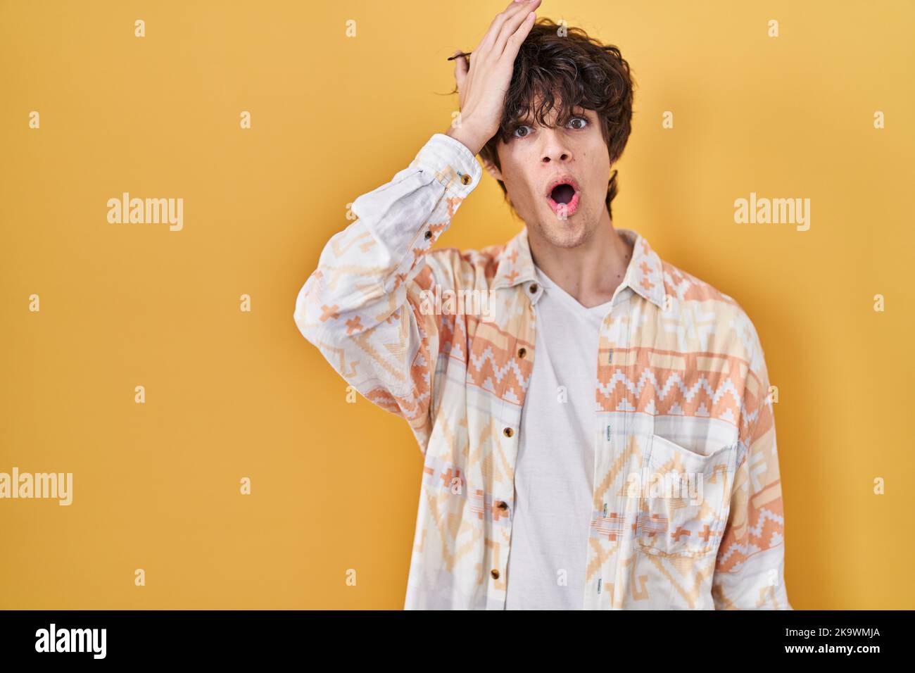 Young man wearing casual summer shirt surprised with hand on head for ...