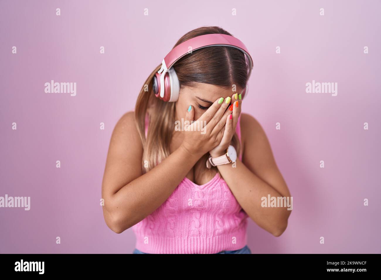 Young blonde woman listening to music using headphones with sad ...