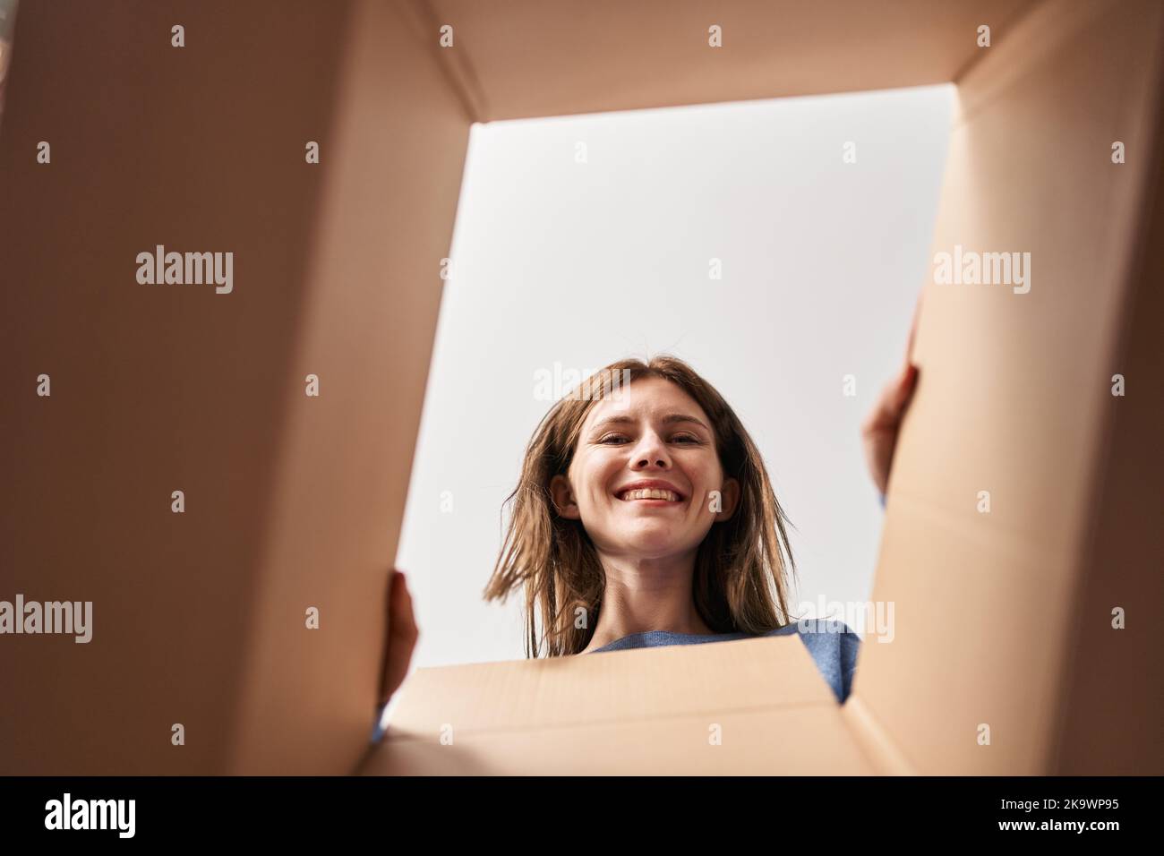 Beautiful woman opening cardboard box smiling with a happy and cool ...