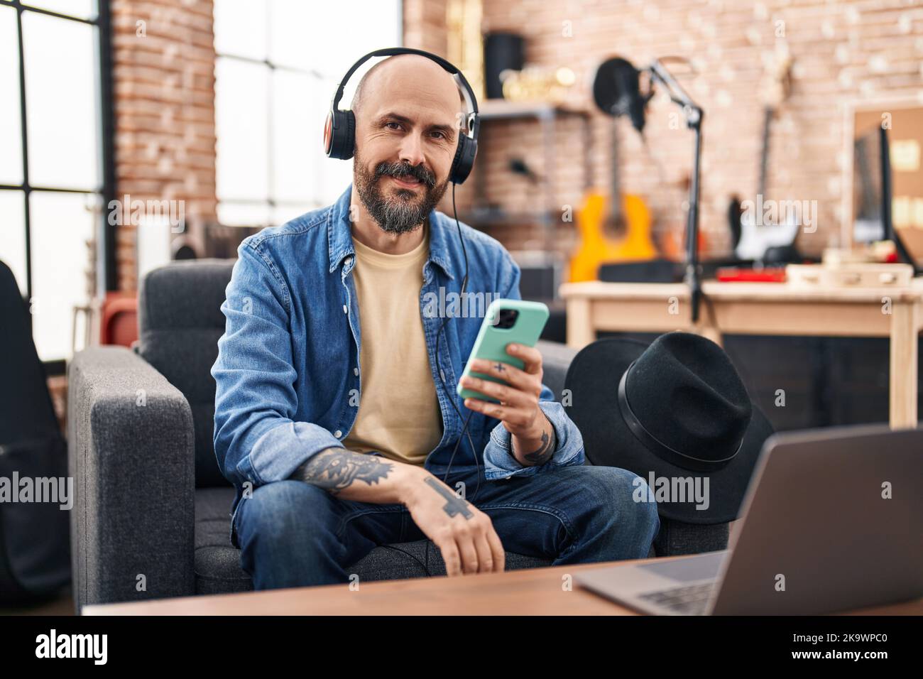 Young bald man musician smiling confident listening to music at music ...
