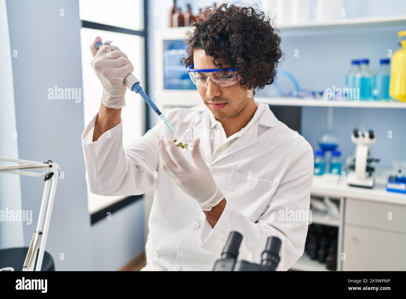 Young hispanic man wearing scientist uniform using pipette at laboratory Stock Photo - Alamy