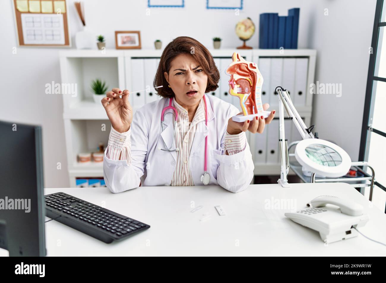 Middle age hispanic doctor woman holding coronavirus infection nasal ...