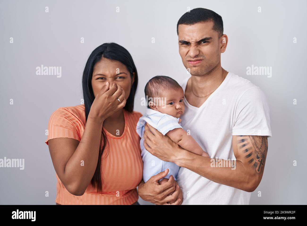 Young hispanic couple with baby standing together over isolated ...