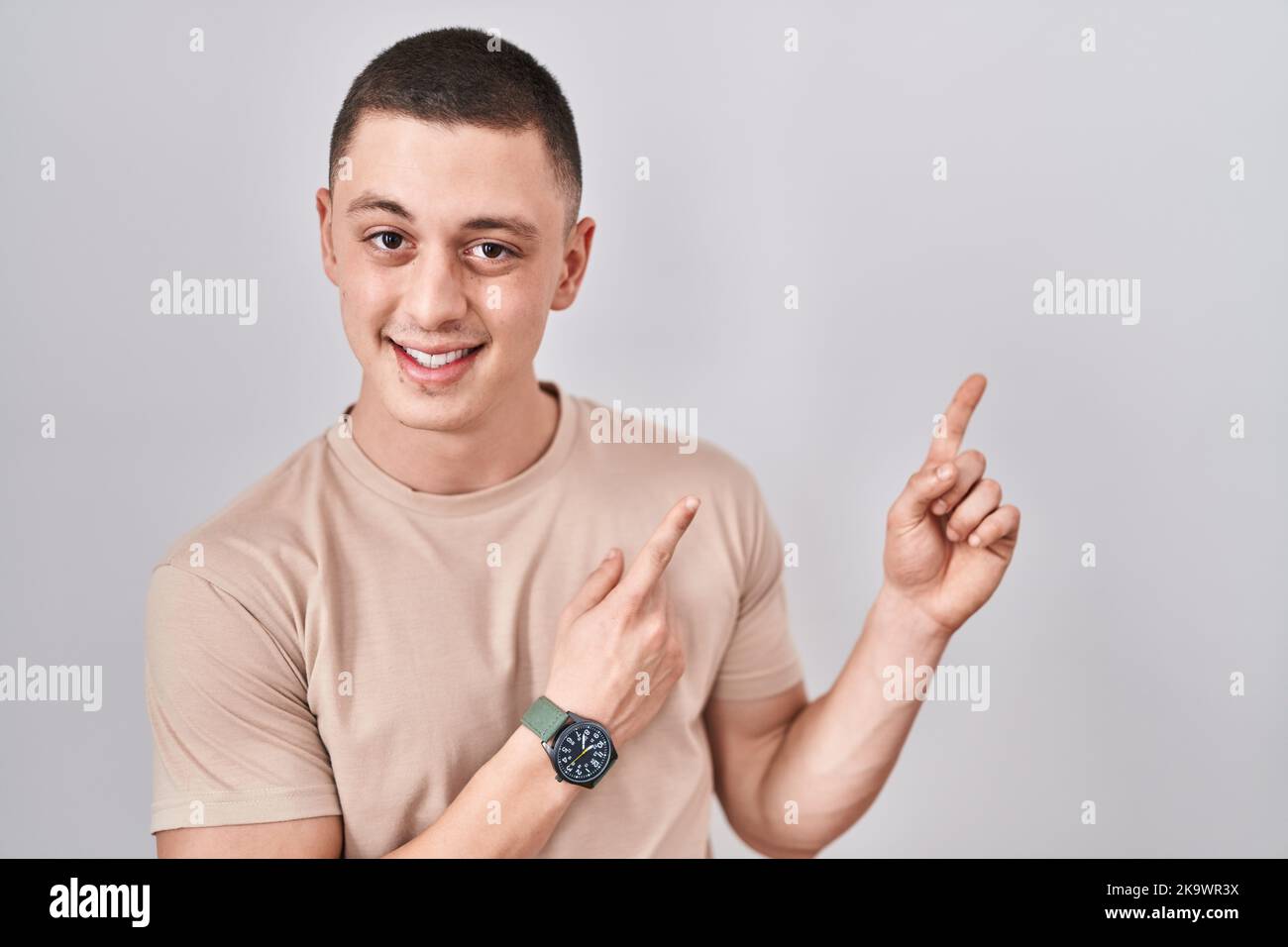 Young man standing over isolated background smiling and looking at the ...