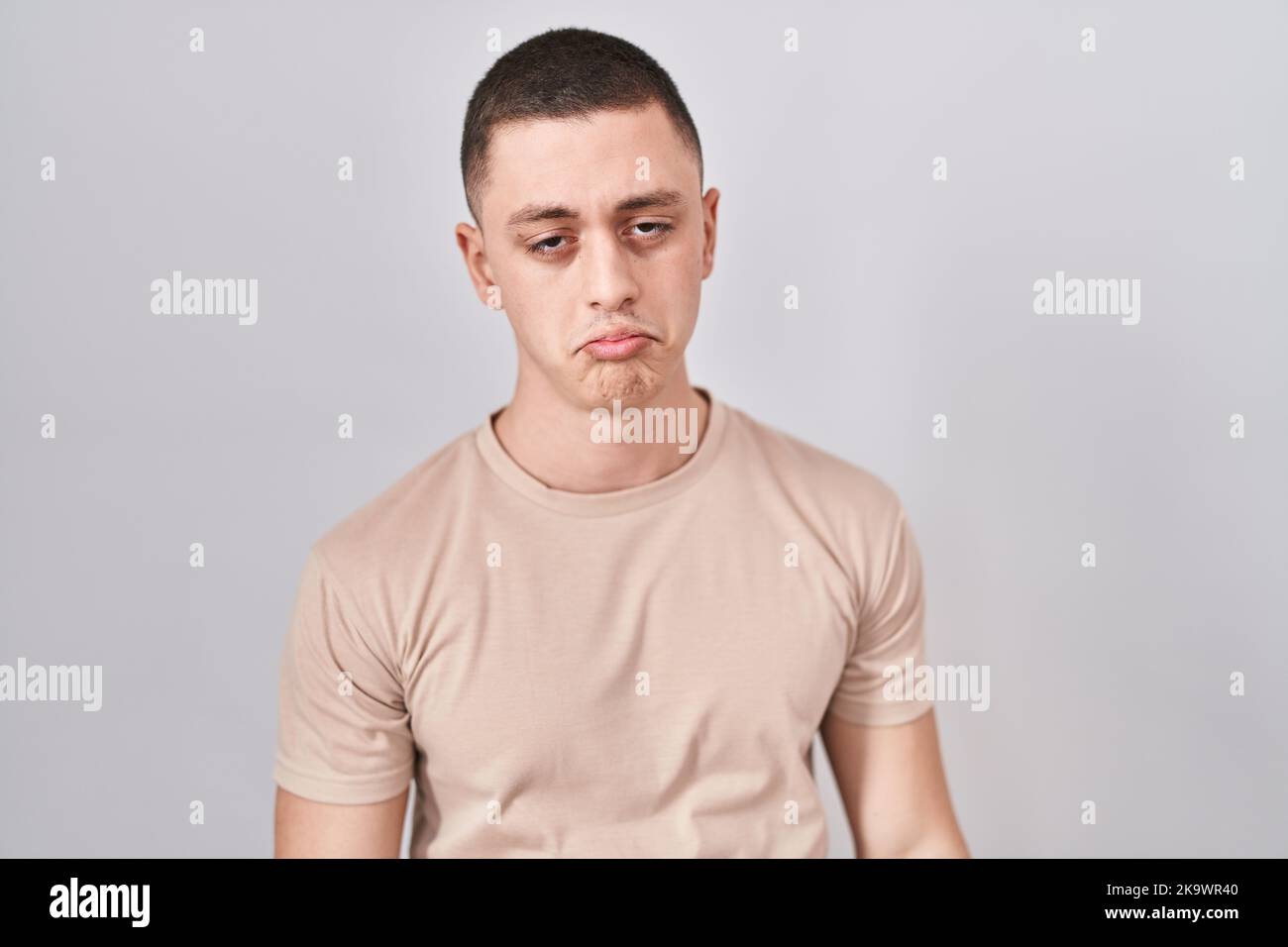 Young man standing over isolated background depressed and worry for ...
