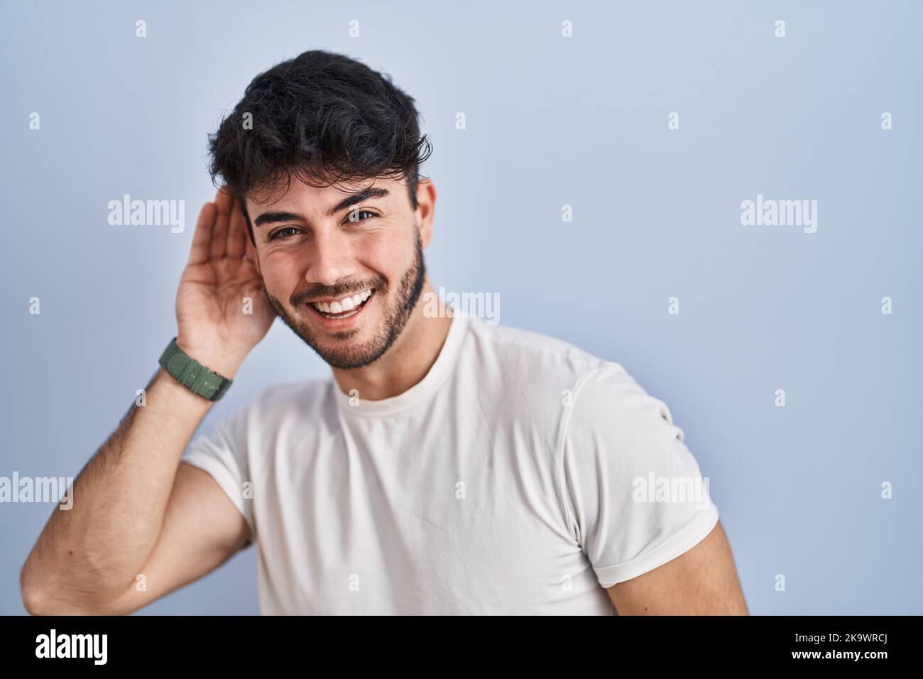 Hispanic man with beard standing over white background smiling with ...