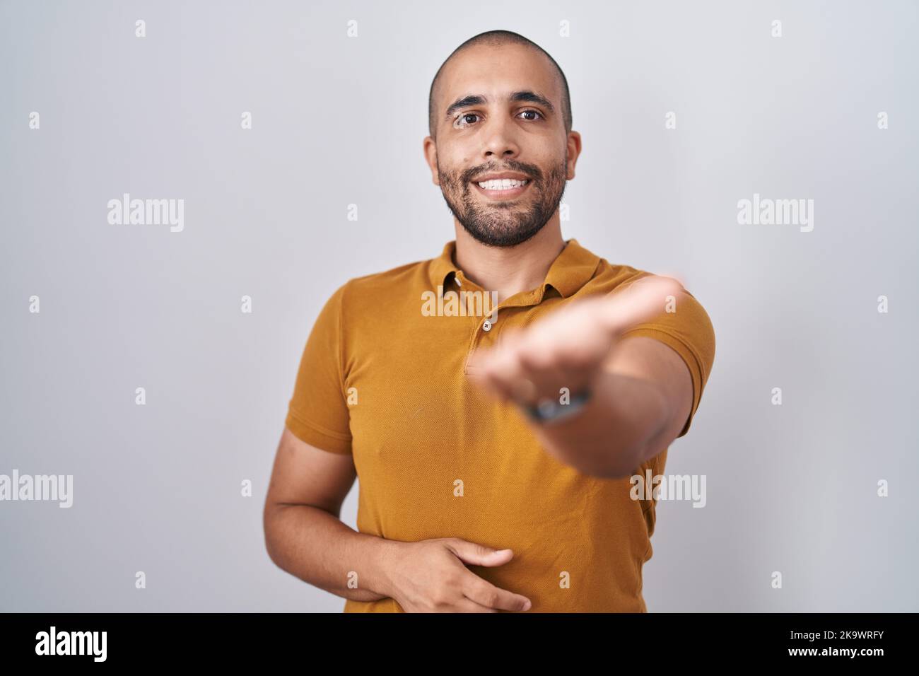 Hispanic man with beard standing over white background smiling cheerful ...