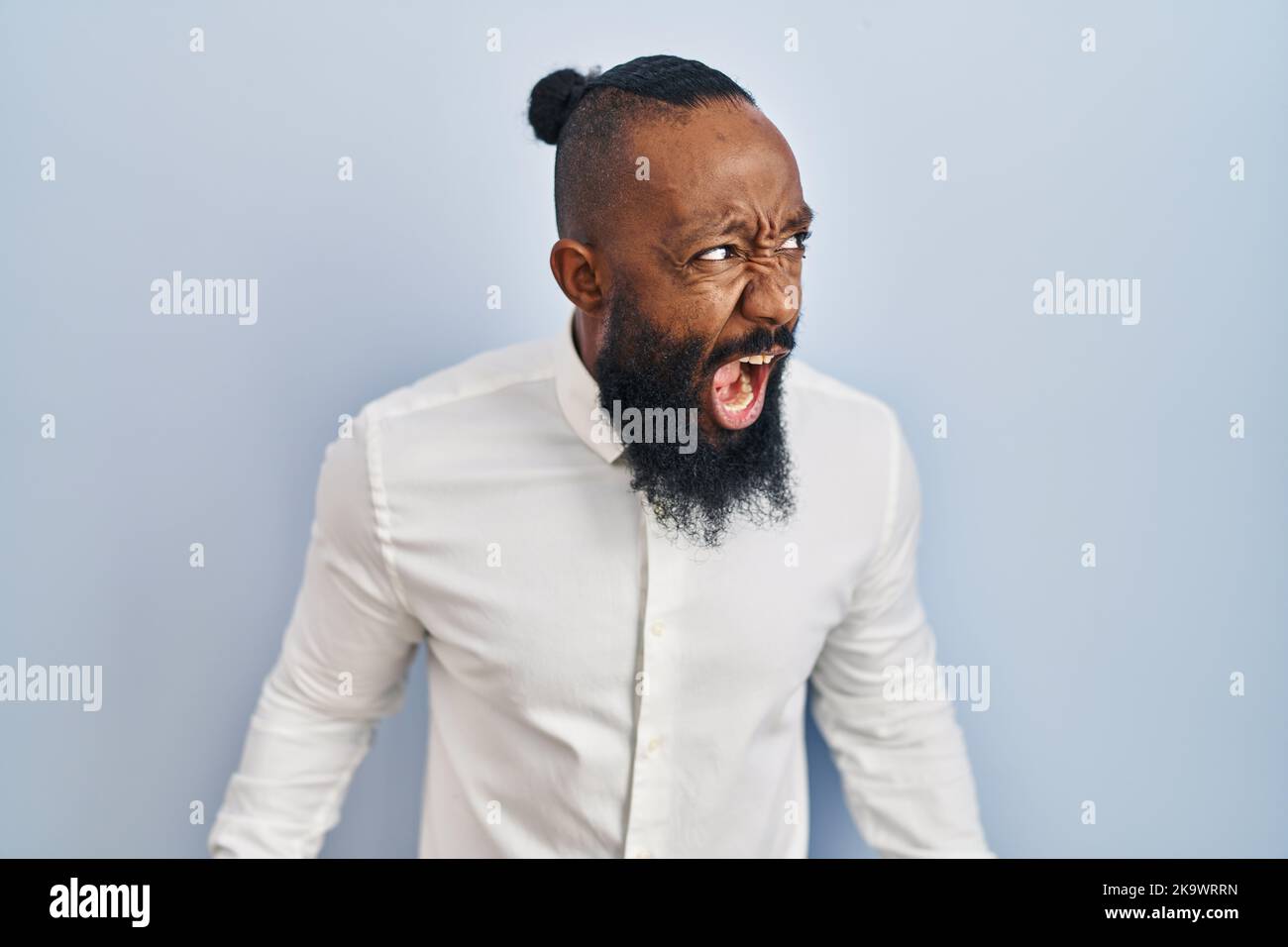African american man standing over blue background angry and mad ...
