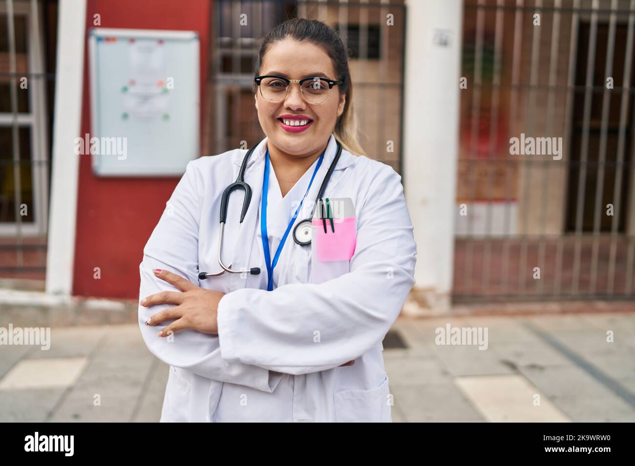 Young beautiful plus size woman doctor smiling confident standing with ...