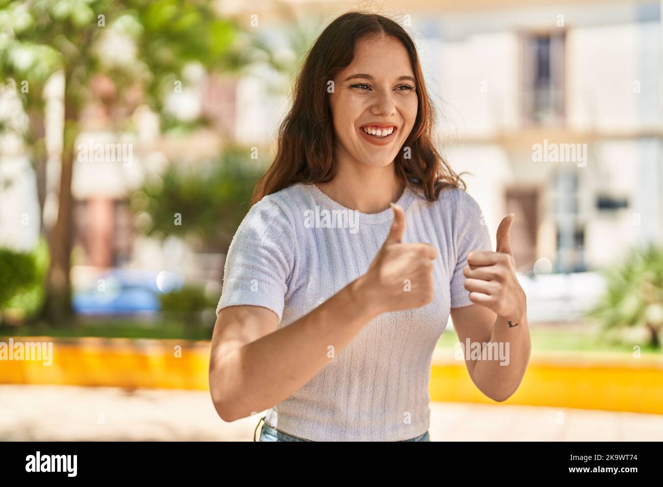 Young woman smiling confident doing ok sign with thumbs up at park ...