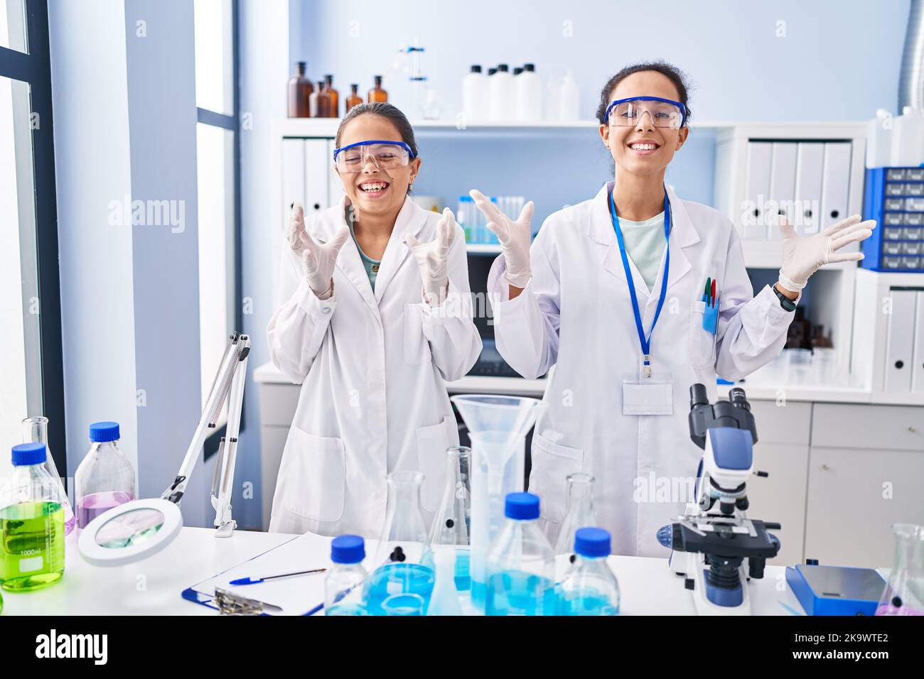 Young mother and daughter at scientist laboratory celebrating mad and ...