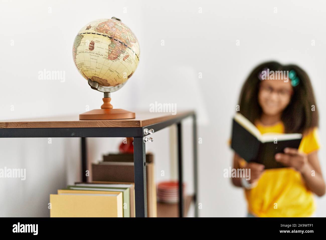 African american girl smiling confident reading geography book at home ...