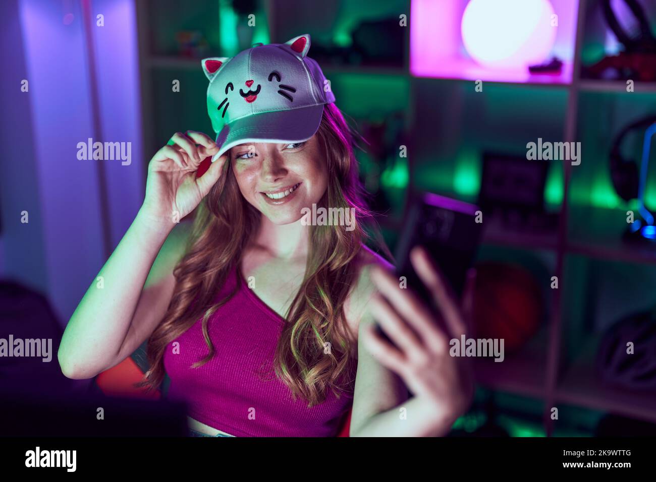 Young woman streamer using computer make selfie by smarpthone at gaming ...