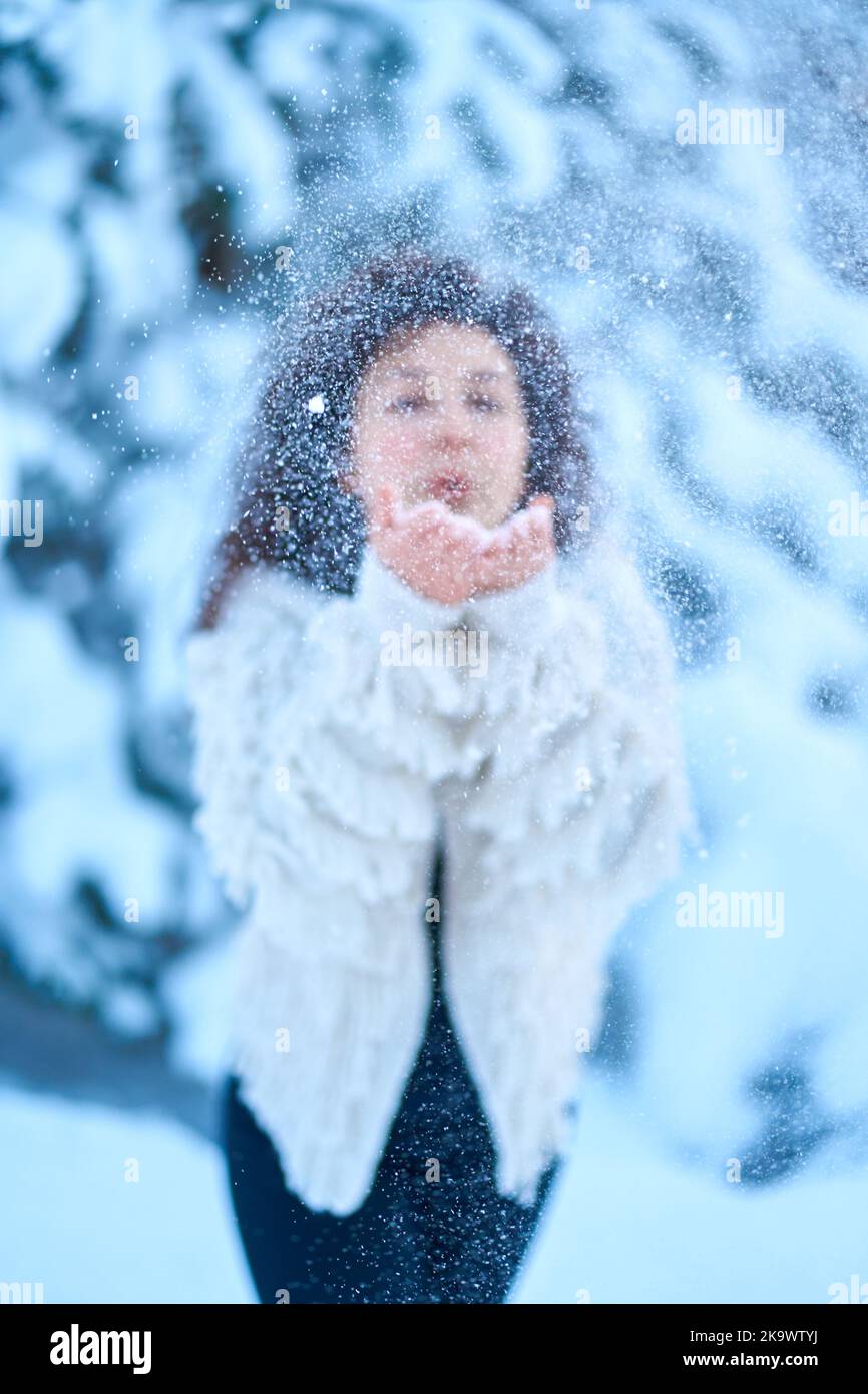 A woman happily playing with snow in a snow-covered winter forest Stock ...
