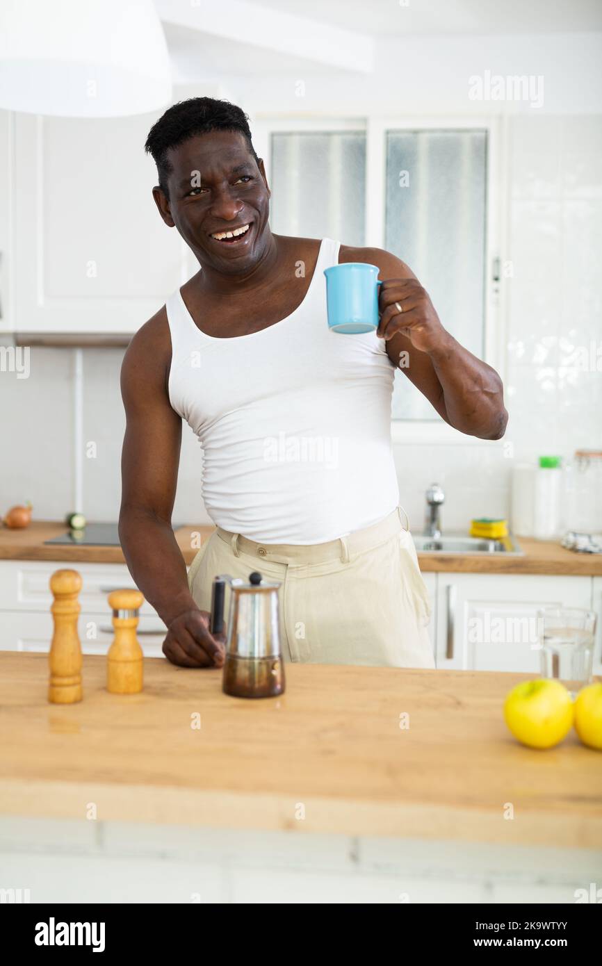 African american man pouring coffee from coffee pot for breakfast in ...