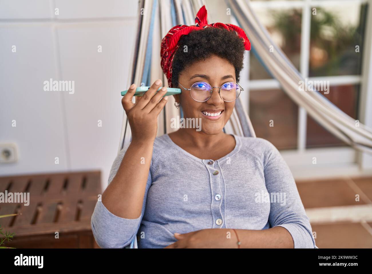 African american woman listening voice message by smartphone lying on ...