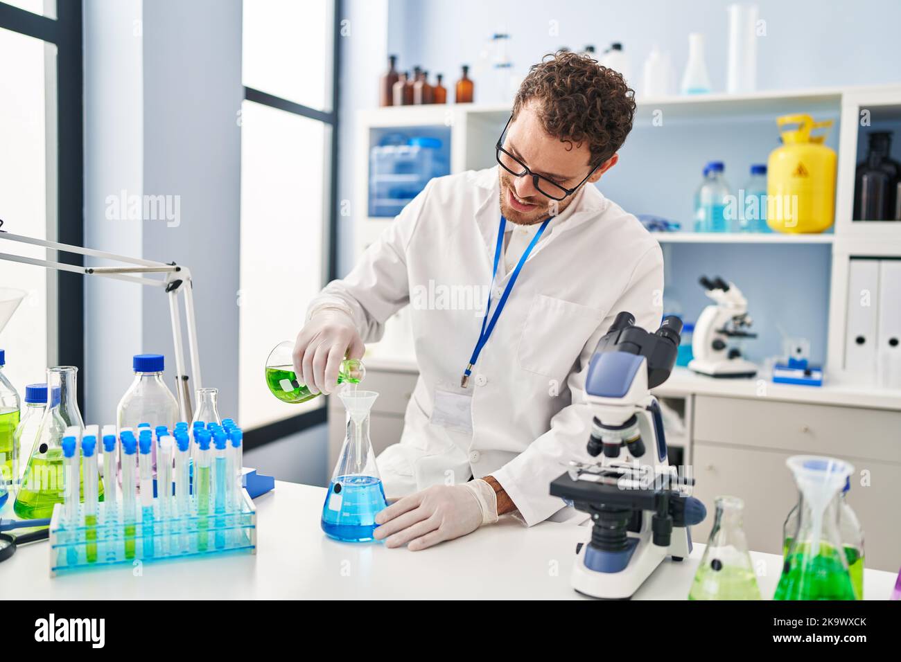 Young hispanic man scientist measuring liquid at laboratory Stock Photo ...
