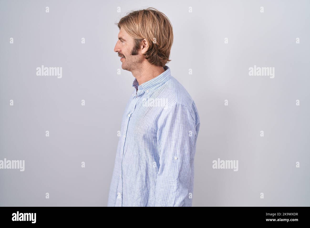 Caucasian man with mustache standing over white background looking to ...