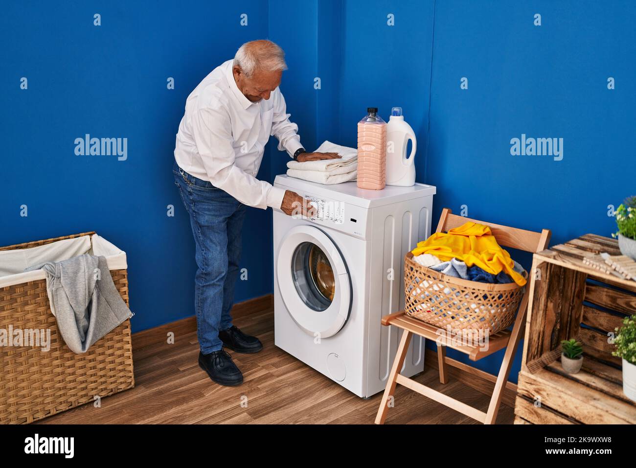 Senior man turning on washing machine at laundry room Stock Photo - Alamy