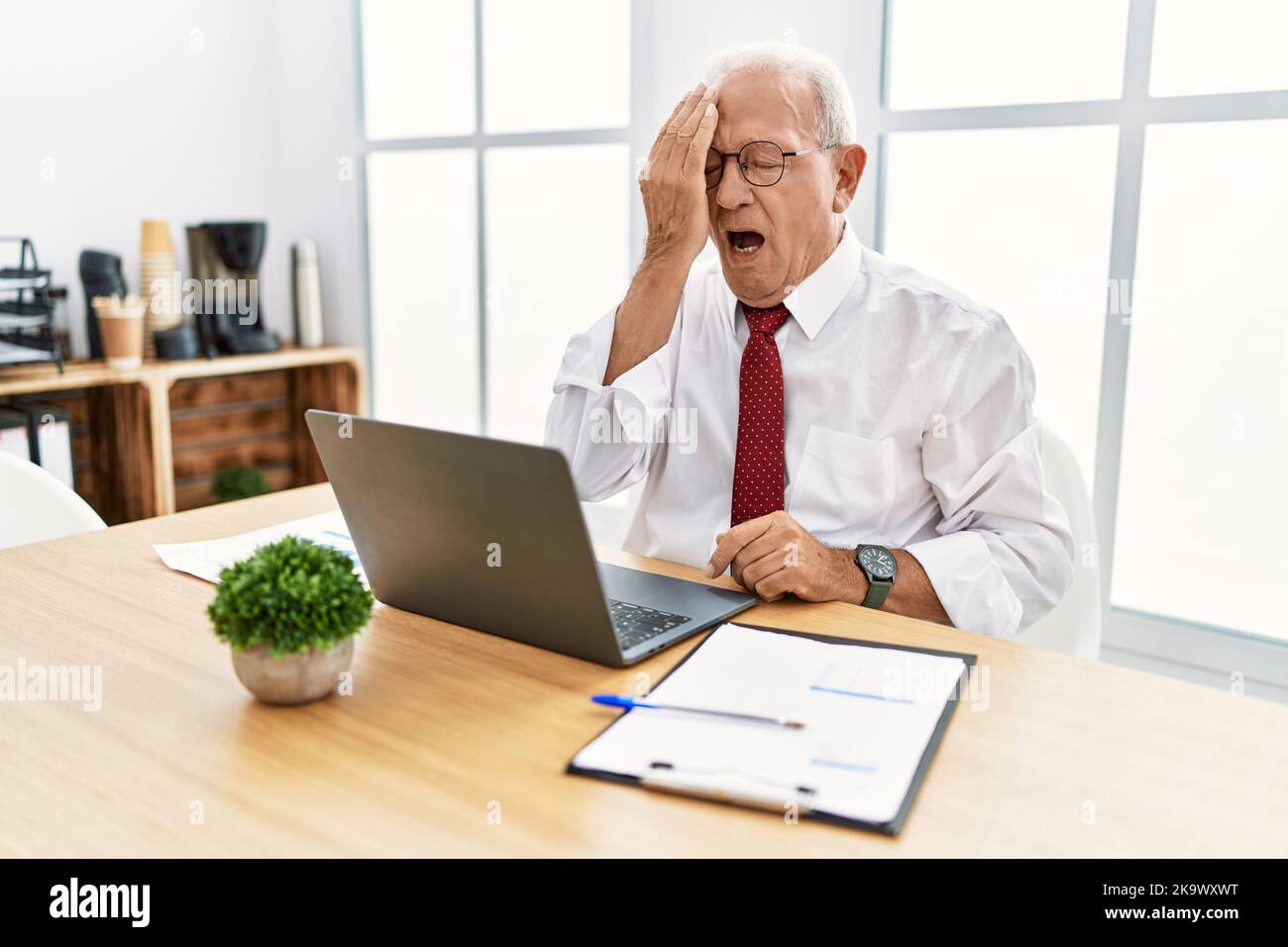 Senior man working at the office using computer laptop yawning tired ...