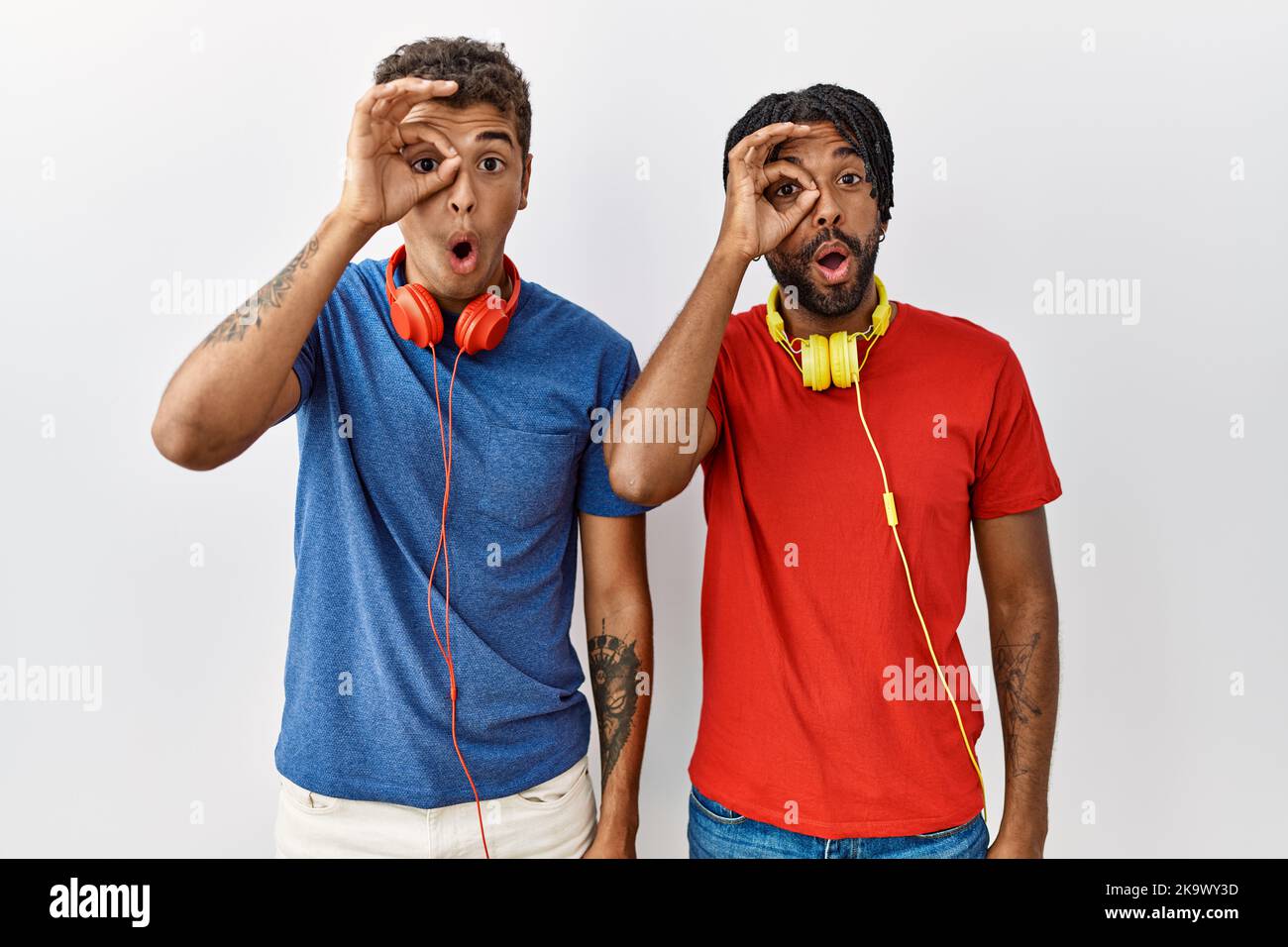 Young hispanic brothers standing over isolated background wearing ...