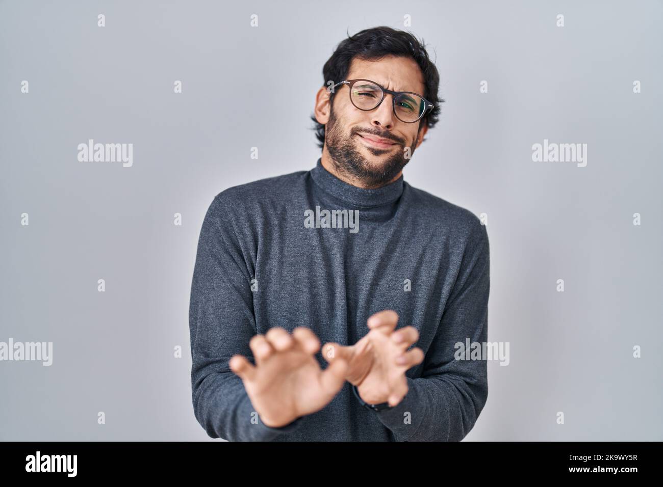 Handsome latin man standing over isolated background disgusted ...