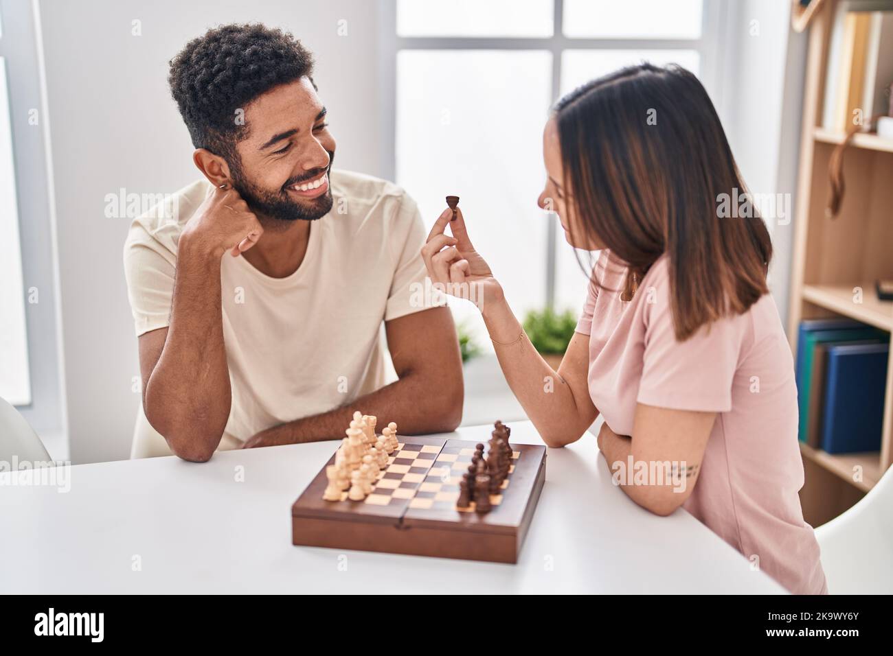 Man and woman couple sitting on table playing chess at home Stock Photo ...